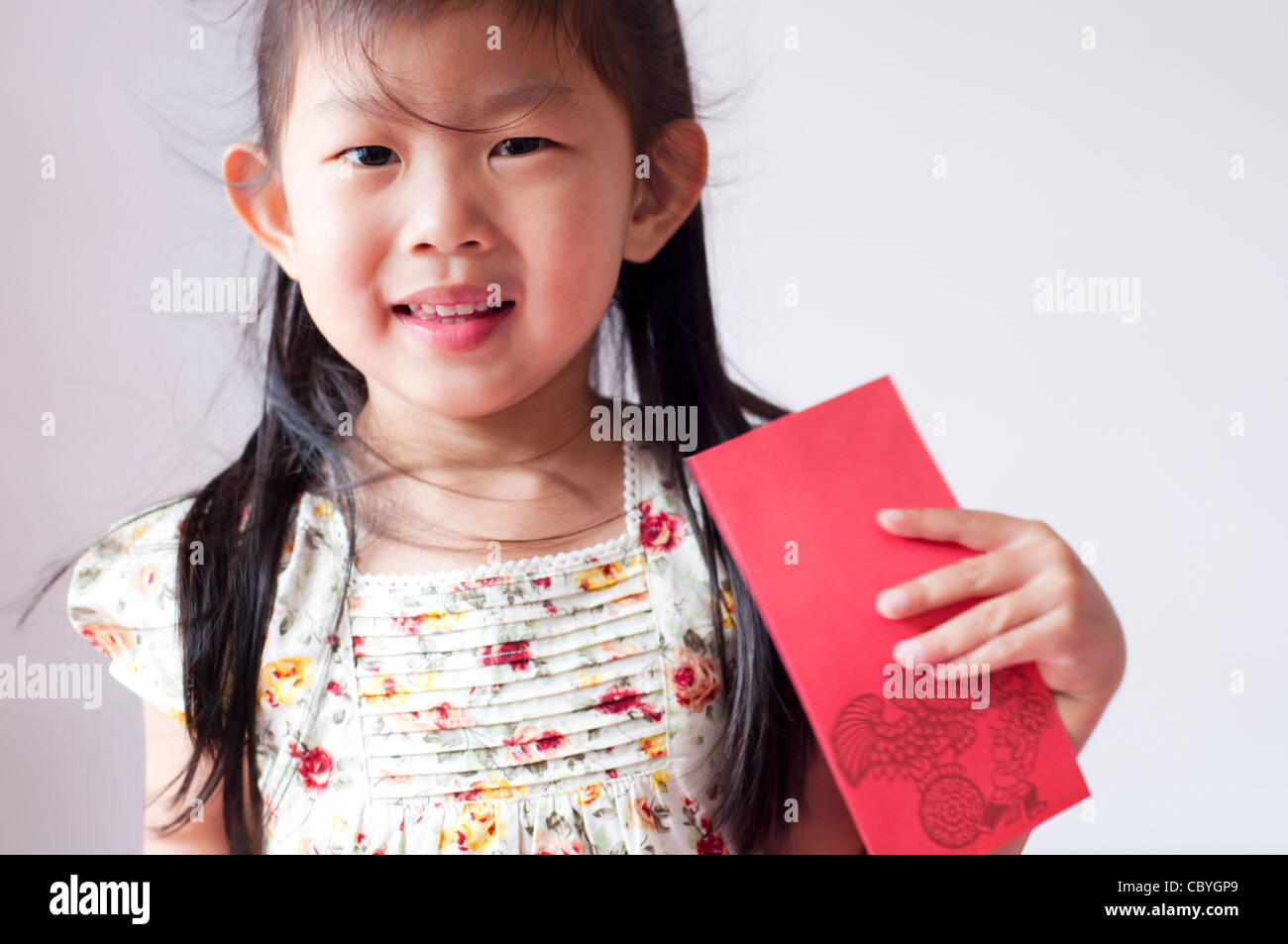 Little asian chinese girl holding a red packet Stock Photo - Alamy