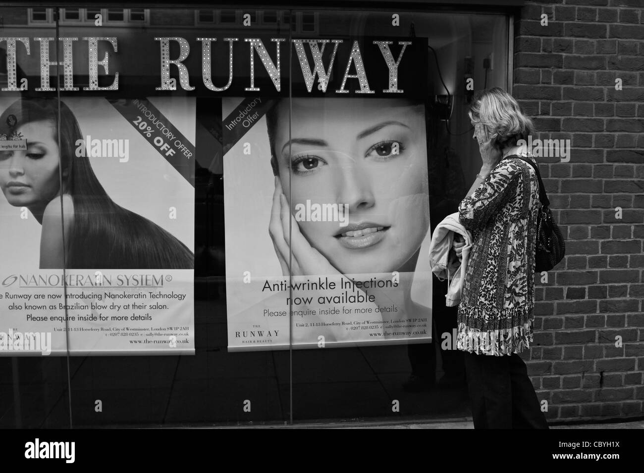 Lady looking in shop window Stock Photo - Alamy