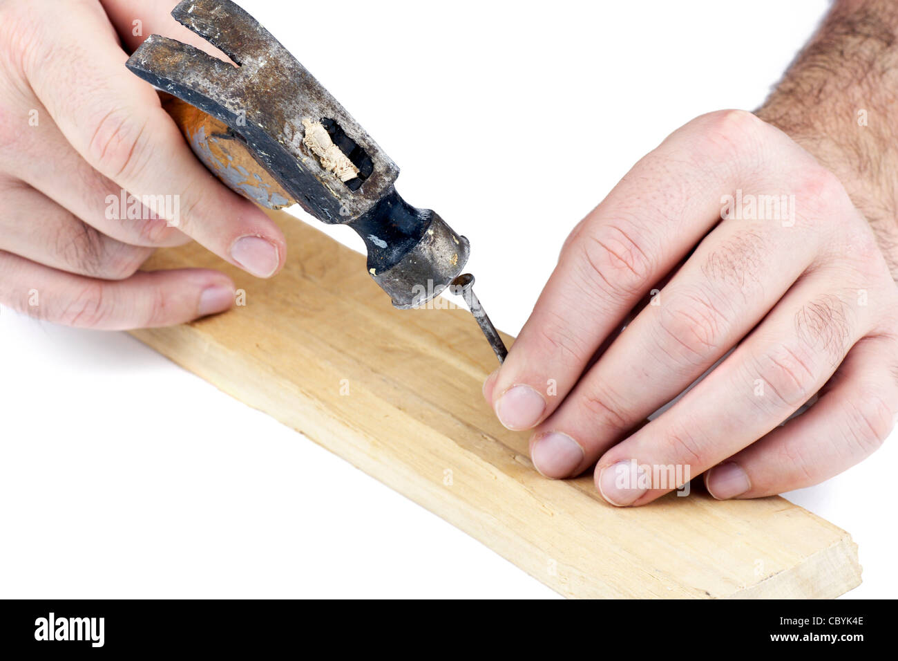 Man's hands hitting a nail on the head with old and used wood hammer on ...