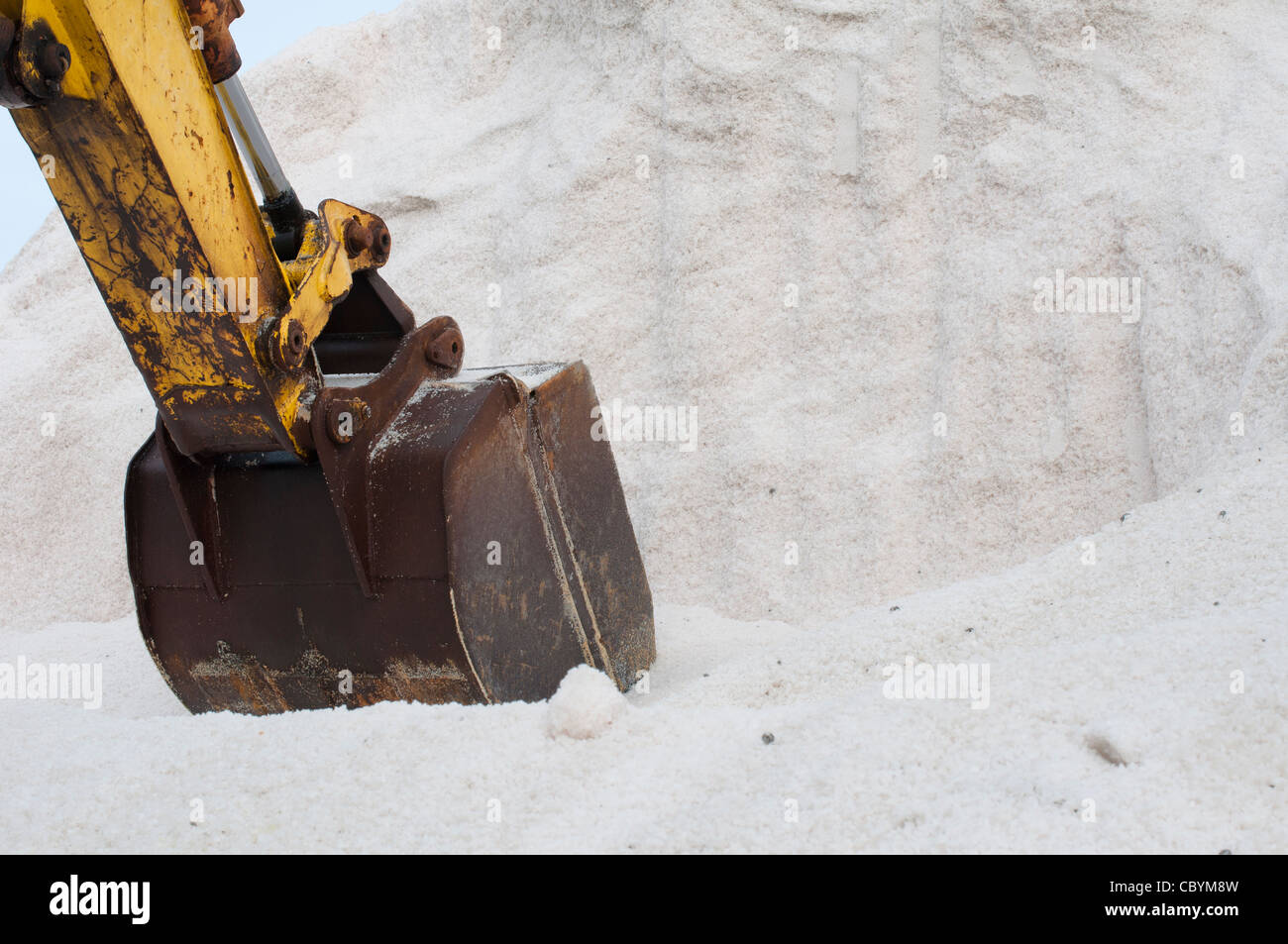 Excavator digging pile white salt Stock Photo - Alamy