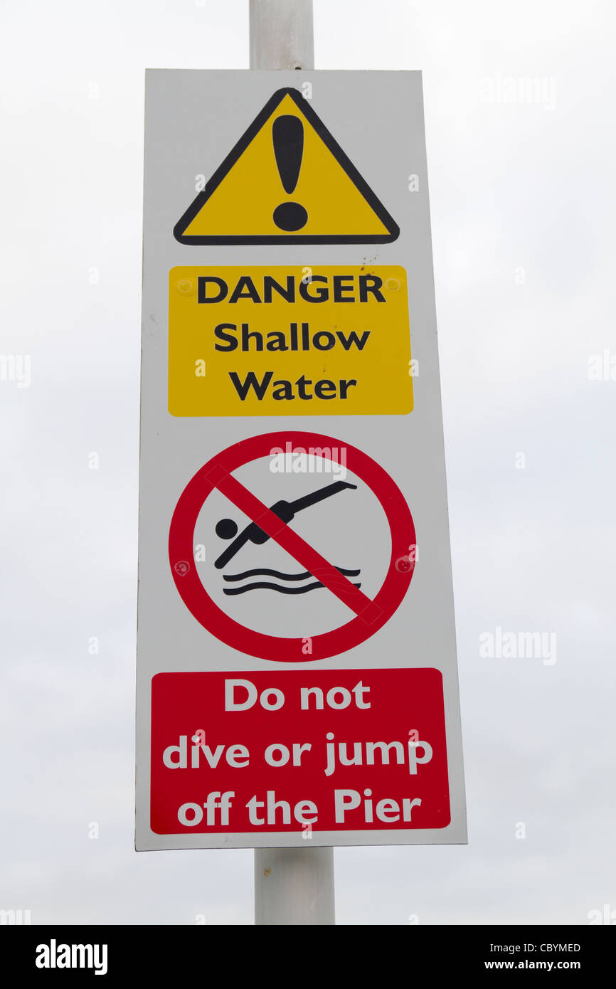 Sign warning people not to jump off the pier Stock Photo - Alamy