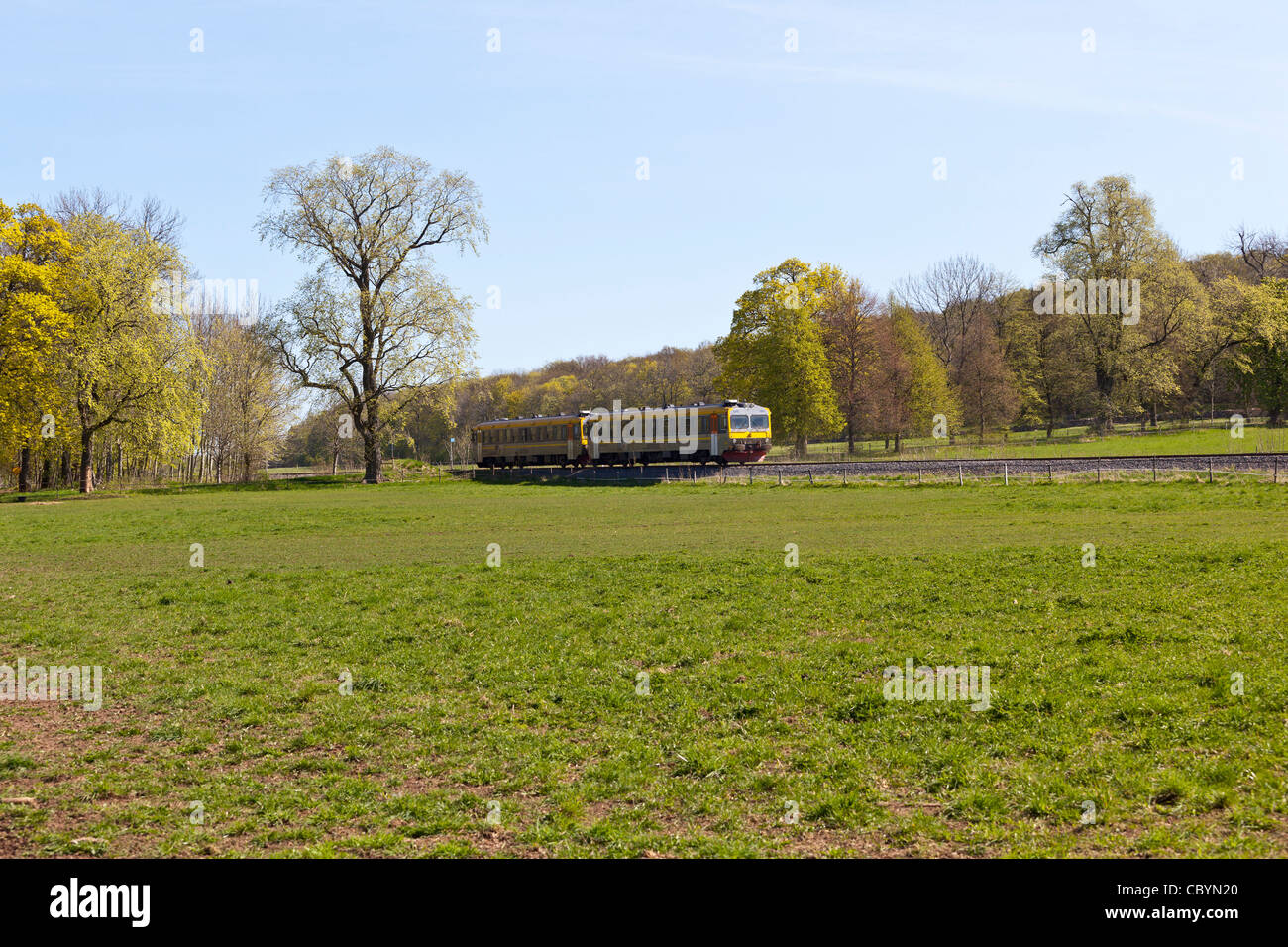 Passanger train in countryside landscape Stock Photo - Alamy