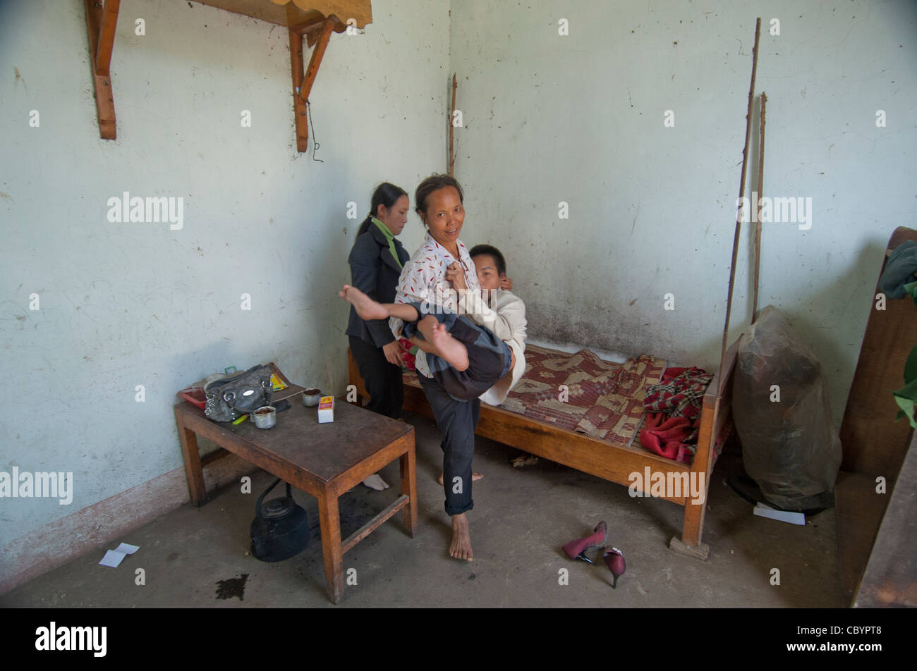 Vietnamese poor mother carrying her disabled child, a handicapped ...