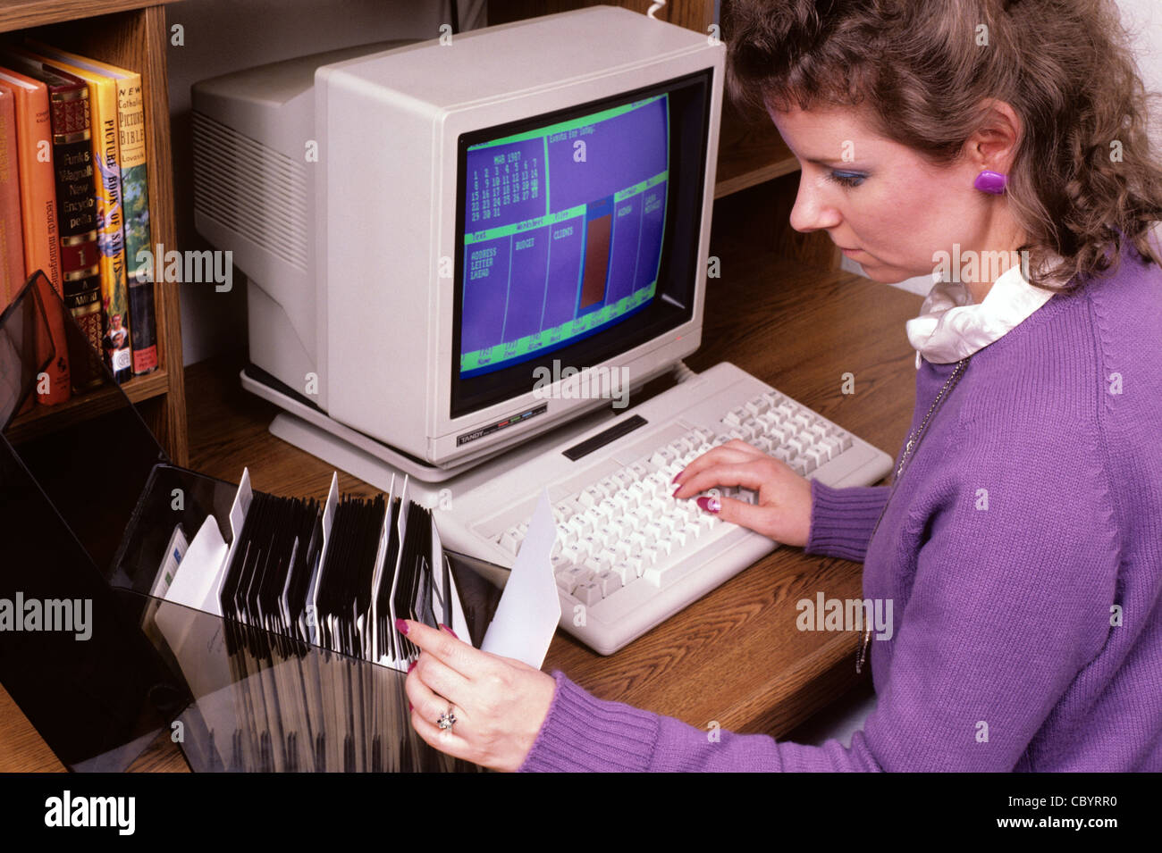 Retro image Woman working on old computer doing her household budget ...