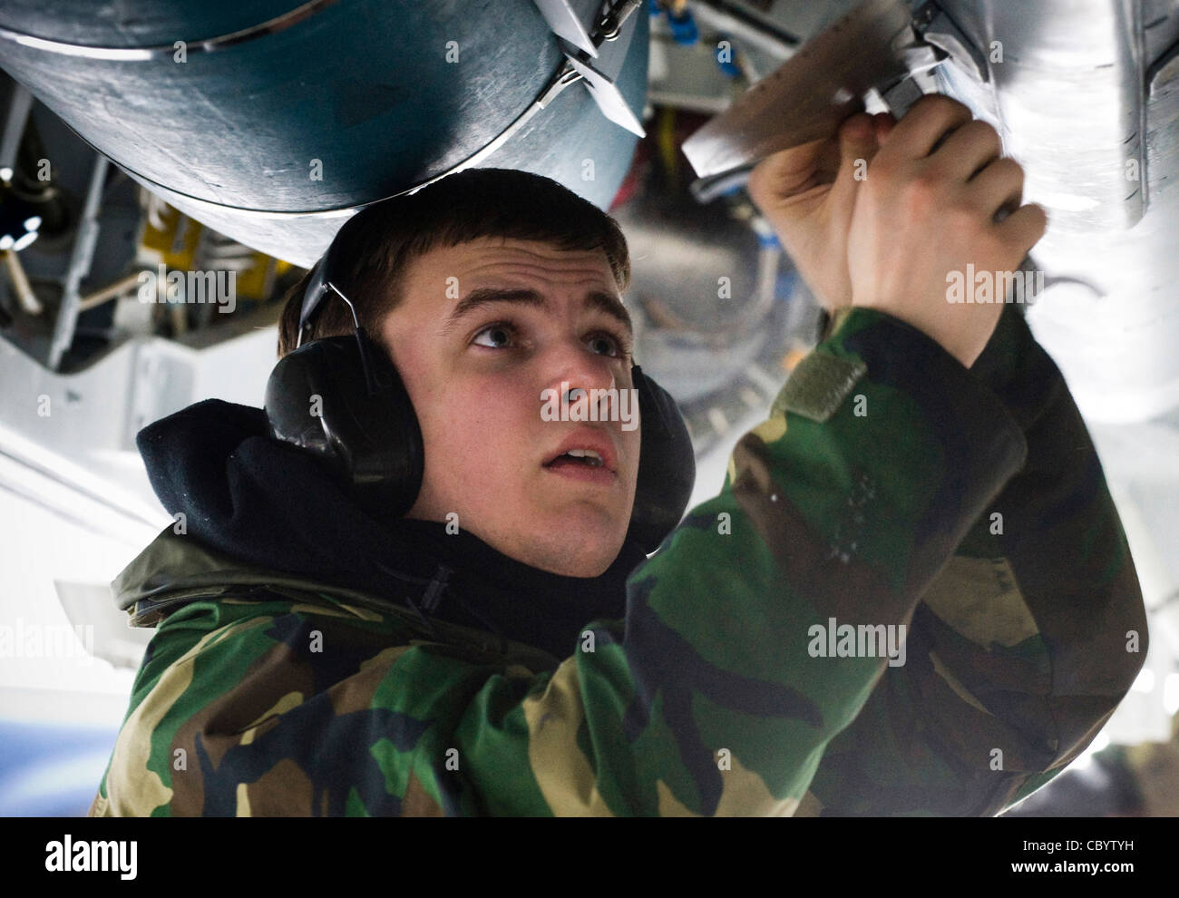 Airman 1st Class Jacob Dean attaches fins to munitions loaded in the F ...