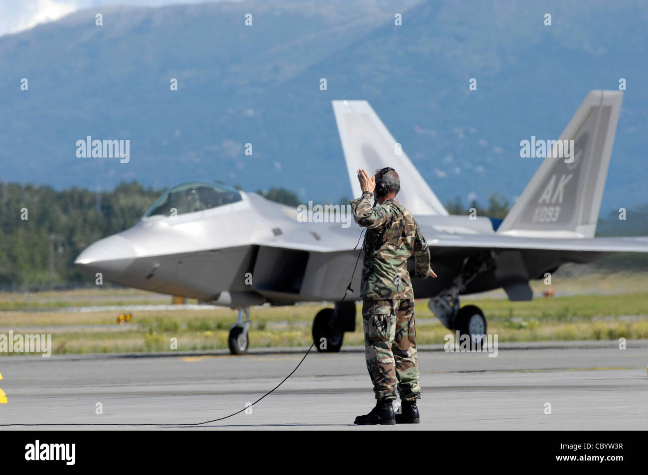 A crew chief marshals an F-22 Raptor into place at Elmendorf Air Force ...