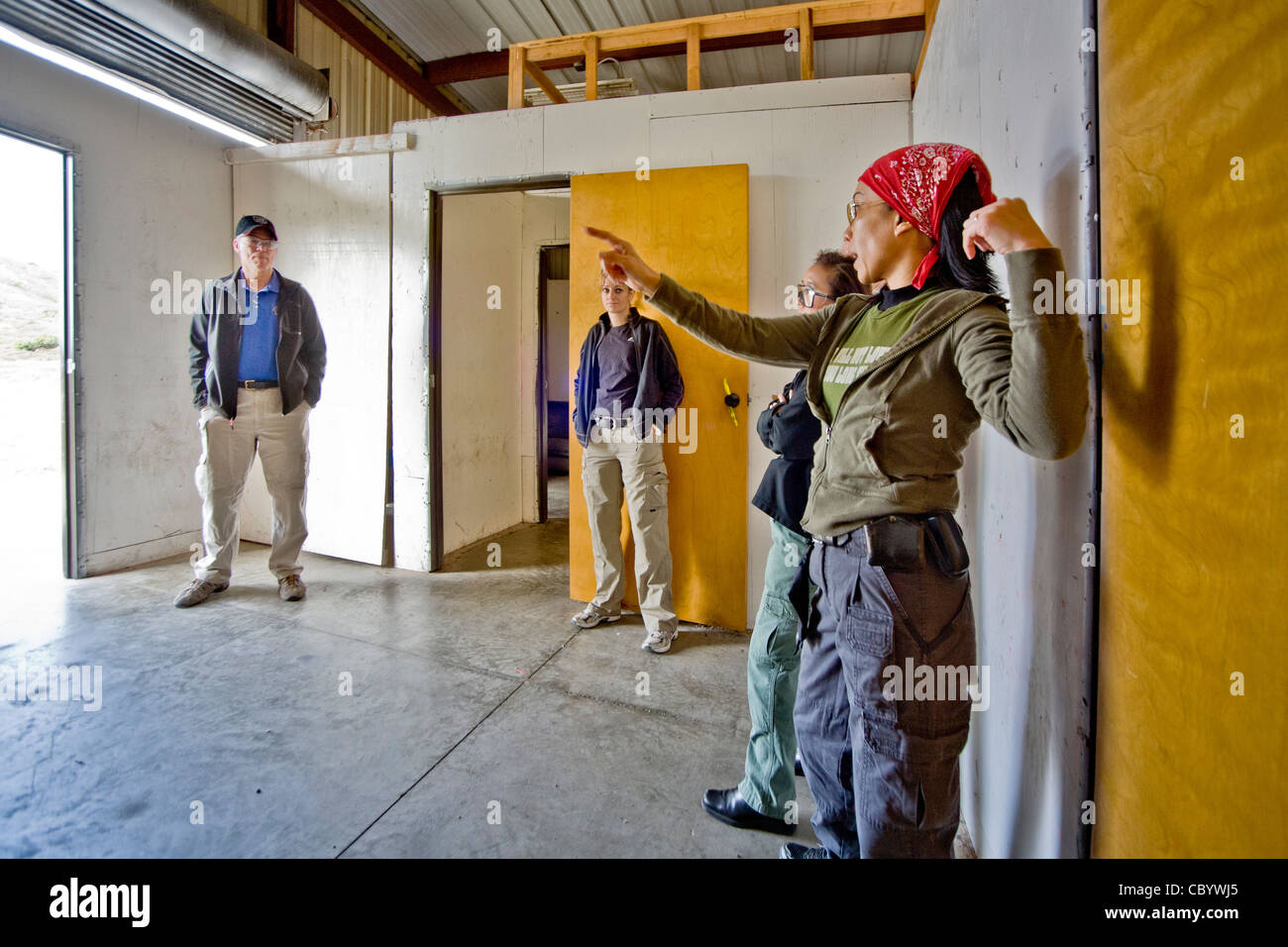 A team of law enforcement agents are instructed in methods for entering ...