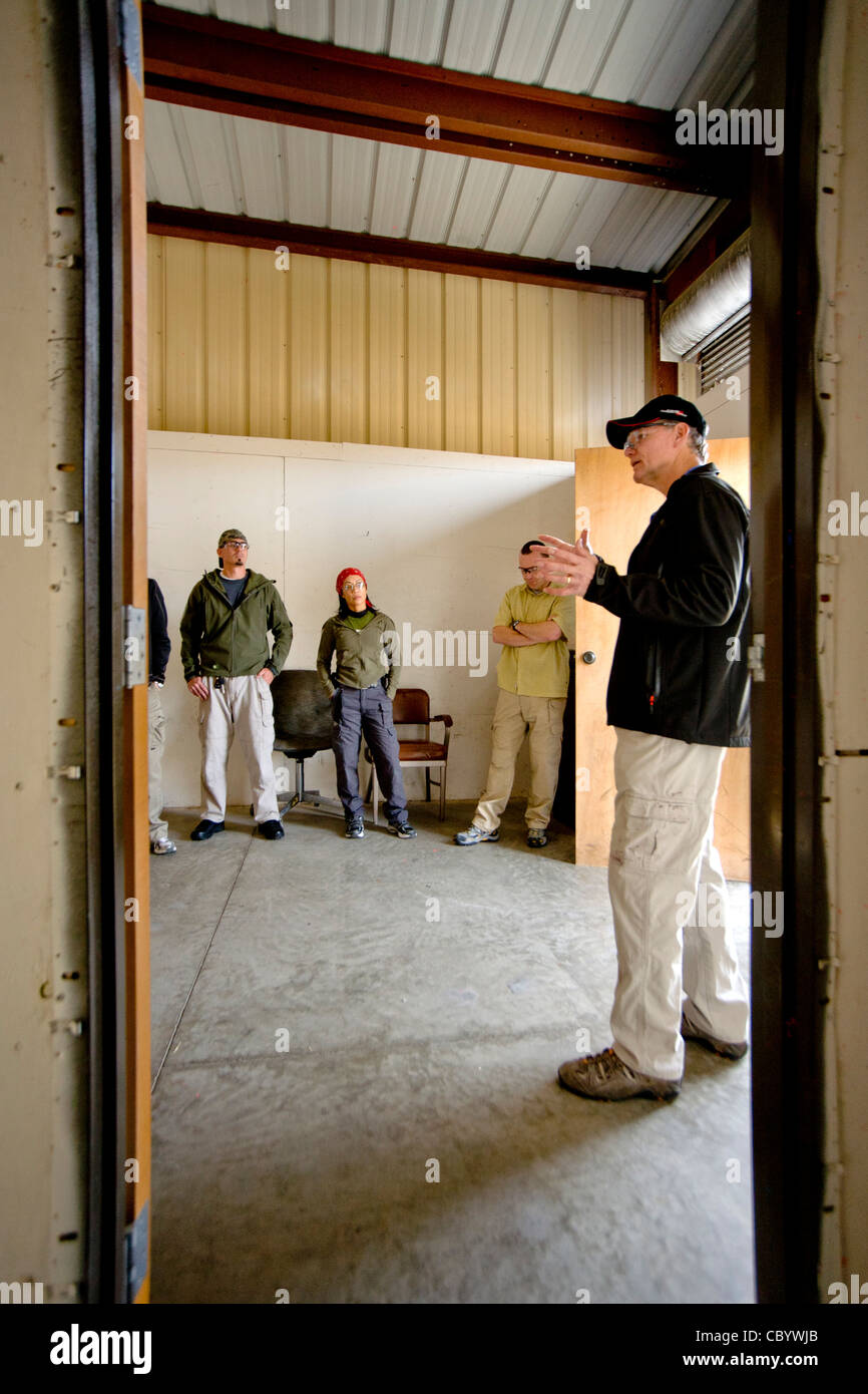 A team of law enforcement agents are instructed in methods for entering ...