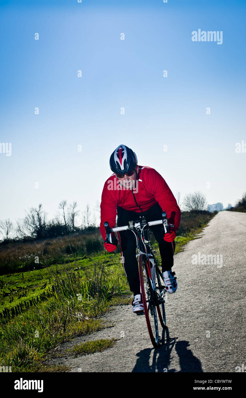 Man on road bike riding down open country road Stock Photo - Alamy