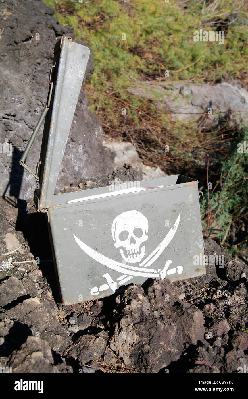 Geocache container with pirate skull design hidden in rocky terrain on ...