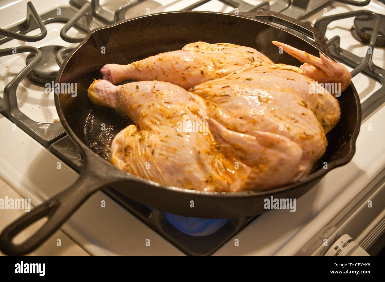 Close up of split whole chicken in frying pan on gas stove Stock Photo ...
