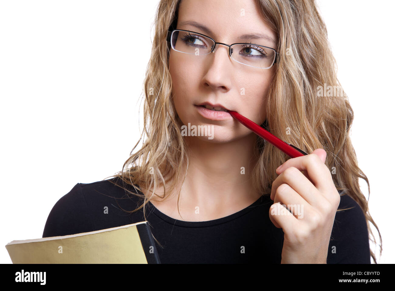 Young student with a pen and notebook thinking Stock Photo - Alamy