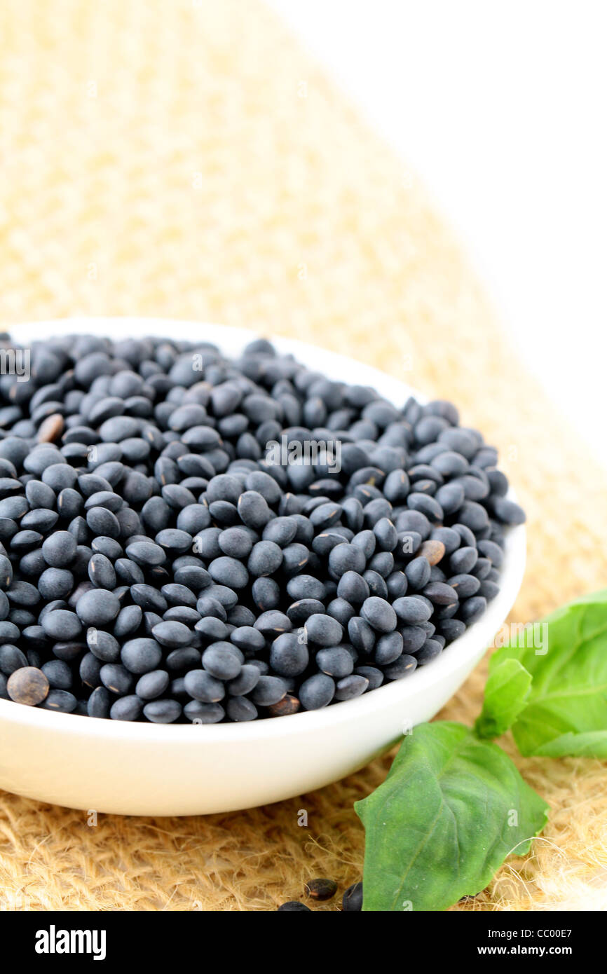 Bowl of black lentils on white background Stock Photo - Alamy