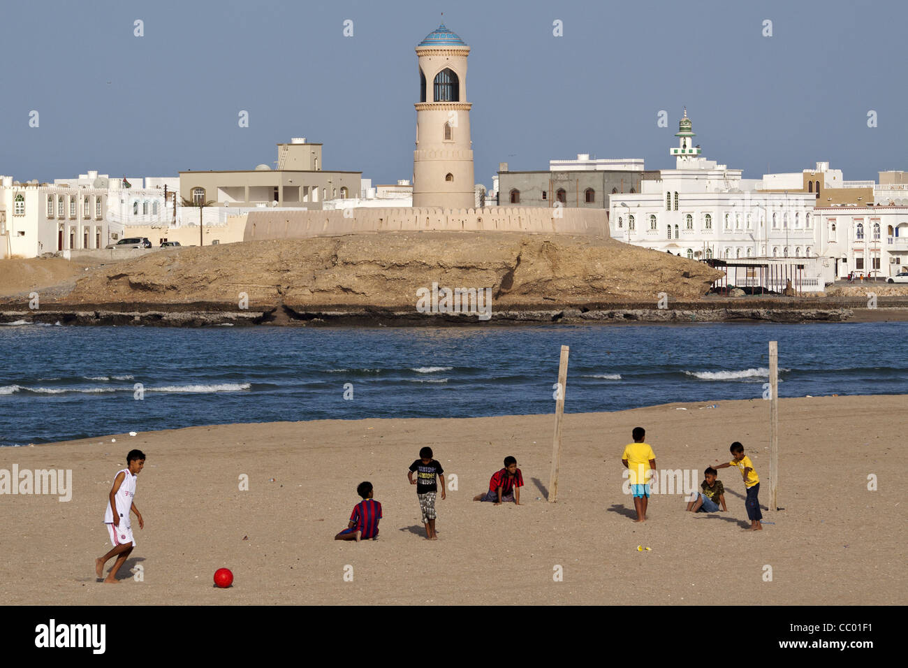 CHILDREN PLAYING SOCCER ON THE BEACH OF SUR, SULTANATE OF OMAN, MIDDLE ...