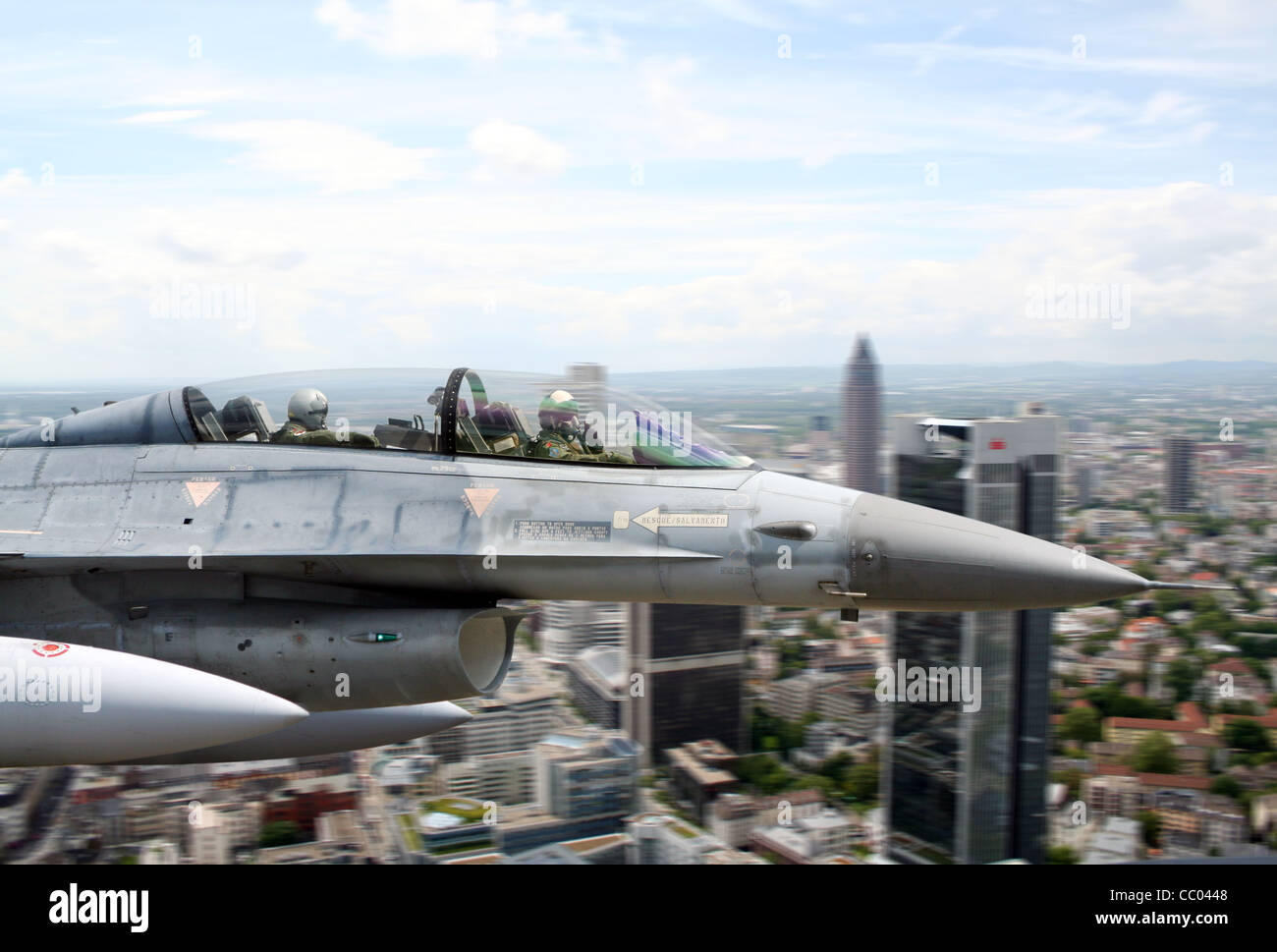 F-16 fighter jet flying over a city Stock Photo - Alamy