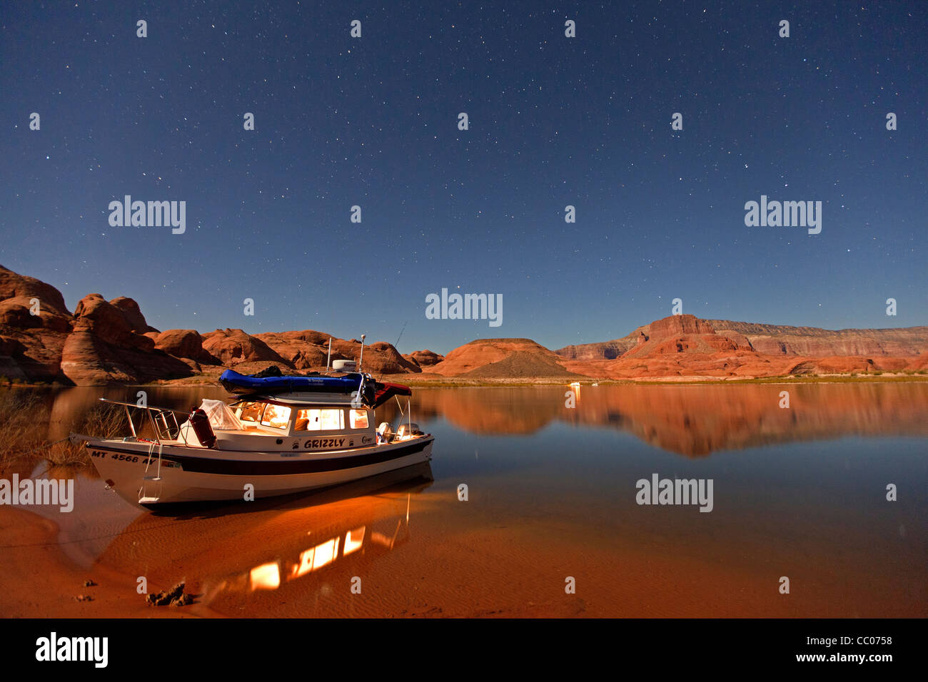 Under a night sky, a C-Dory boat rests in Oak Canyon, Lake Powell, Glen ...