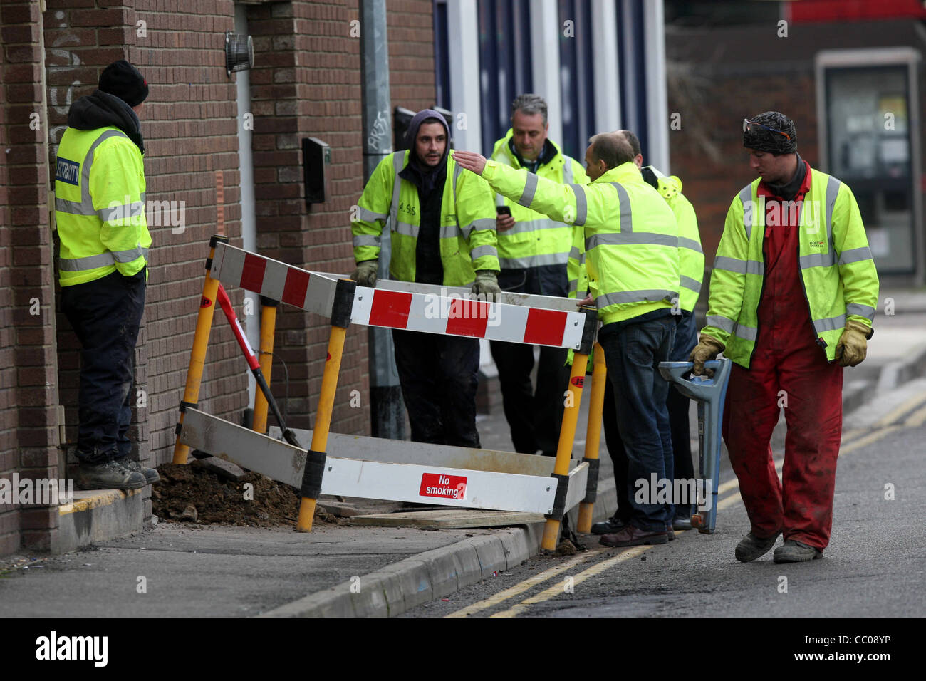 WORKMEN CHECKING A BURST GAS PIPE UNDER A PAVEMENT IN PETERBOROUGH ...