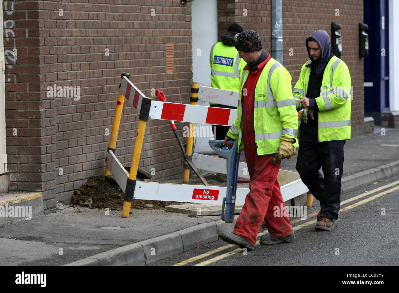 WORKMEN CHECKING A BURST GAS PIPE UNDER A PAVEMENT IN PETERBOROUGH ...