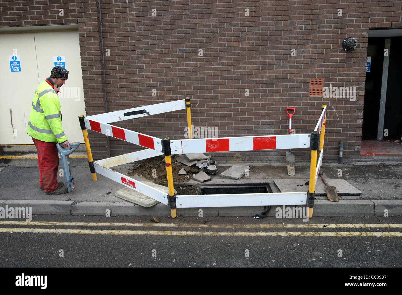WORKMEN CHECKING A BURST GAS PIPE UNDER A PAVEMENT IN PETERBOROUGH ...