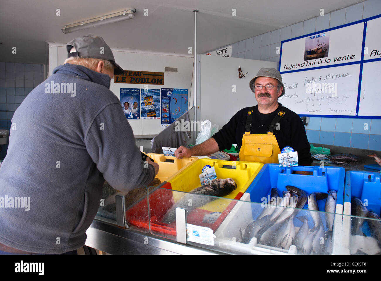 French fisherman selling his fish to a male customer from a market ...