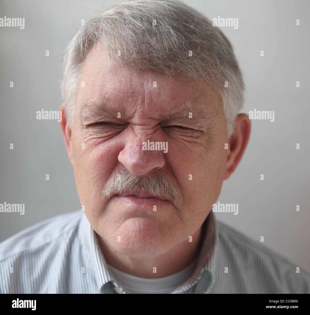 a man wrinkles his nose in disgust Stock Photo - Alamy