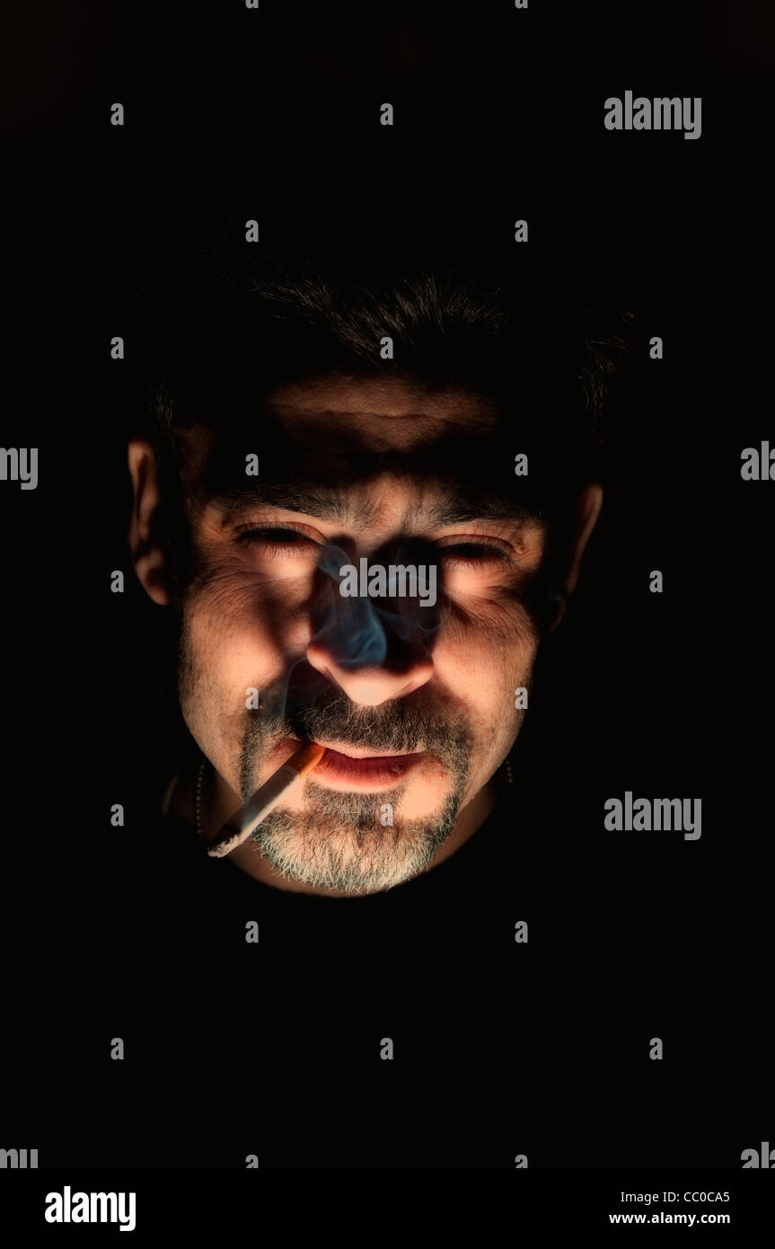 Spooky man smoking cigarette Stock Photo - Alamy