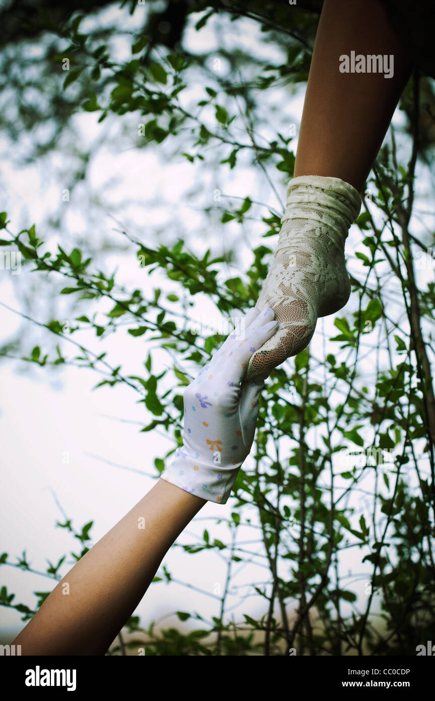 Woman's hand grabbing a foot in lacy socks Stock Photo - Alamy