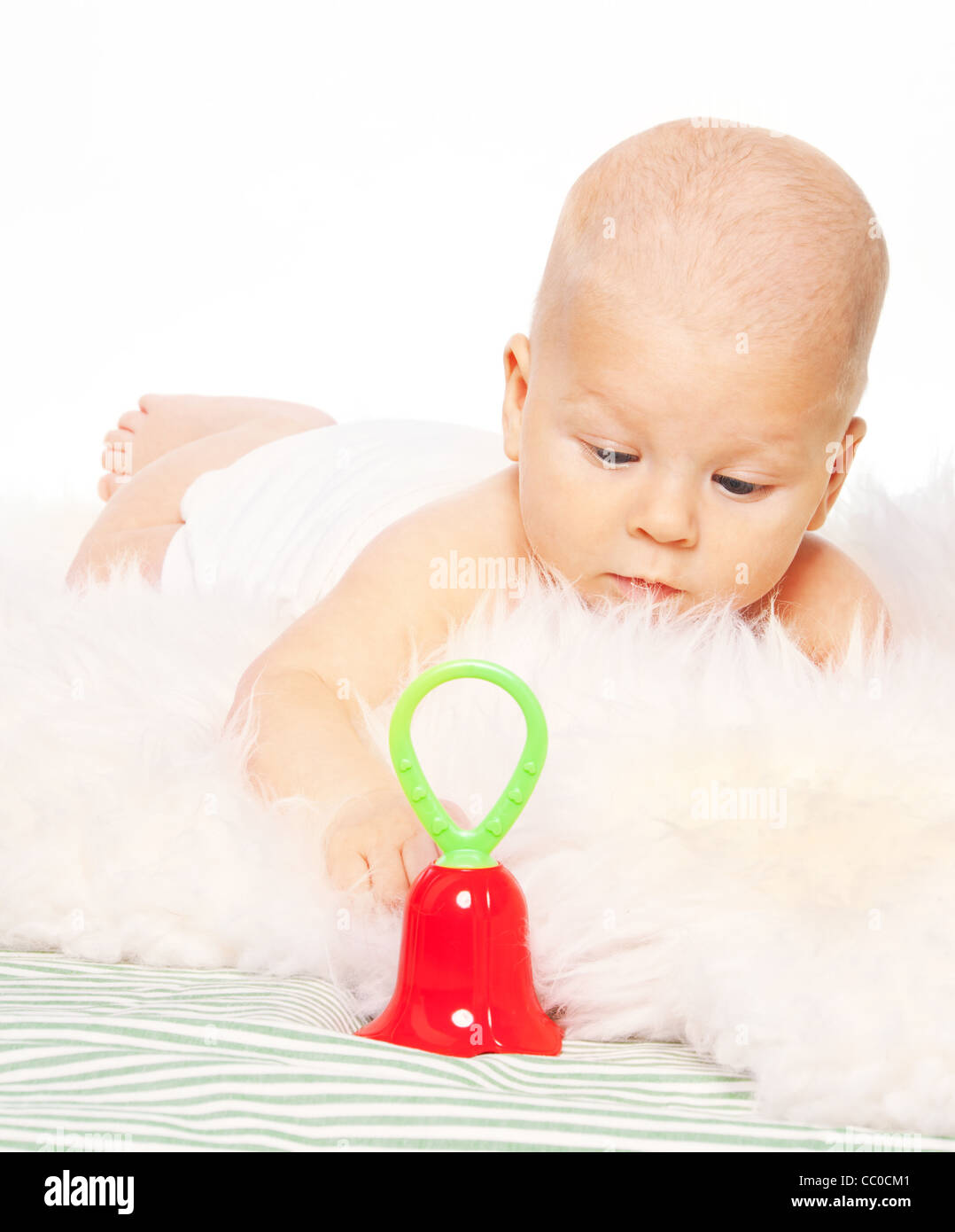 Little baby trying to reach toy laying in the bed Stock Photo - Alamy