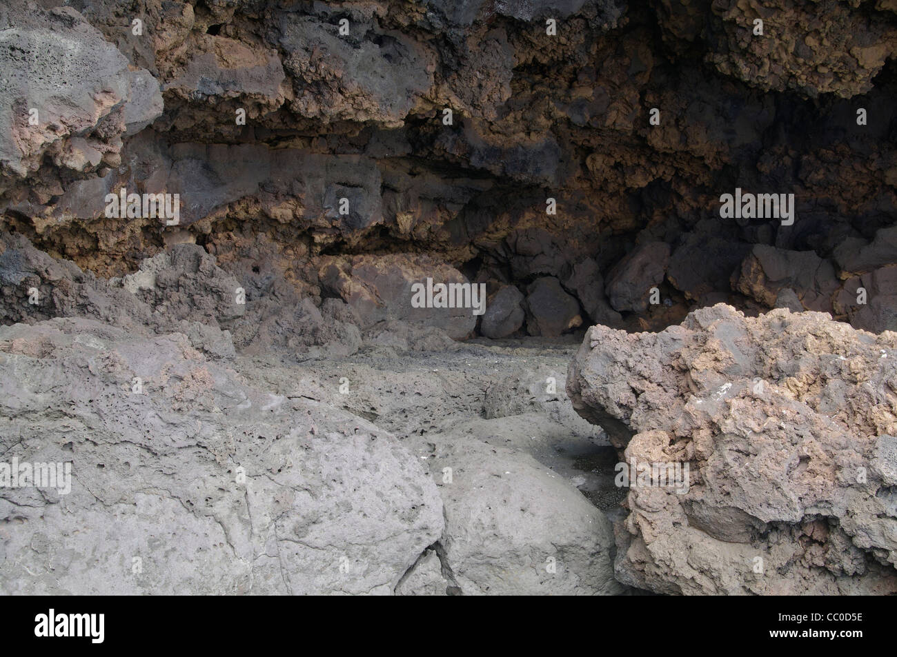 Volcanic sea cave with rugged lava rock formations along the coast of ...