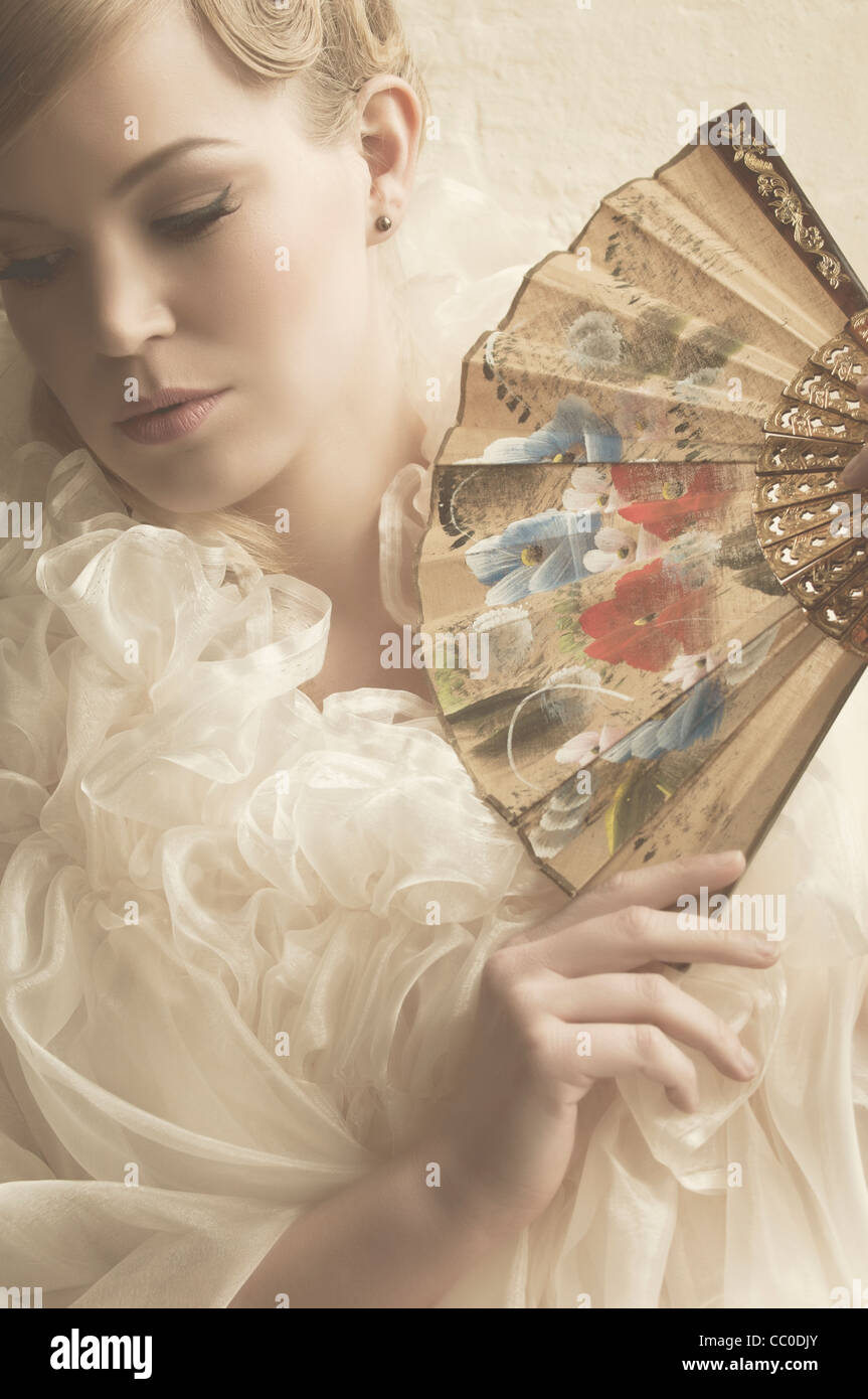 Beautiful woman holding a fan Stock Photo - Alamy