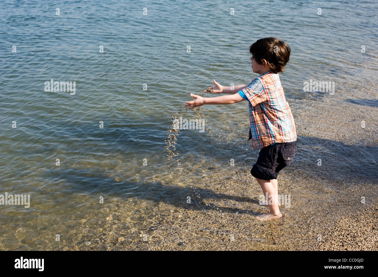 Boy Throwing Pebbles Into The Sea High Resolution Stock Photography and ...