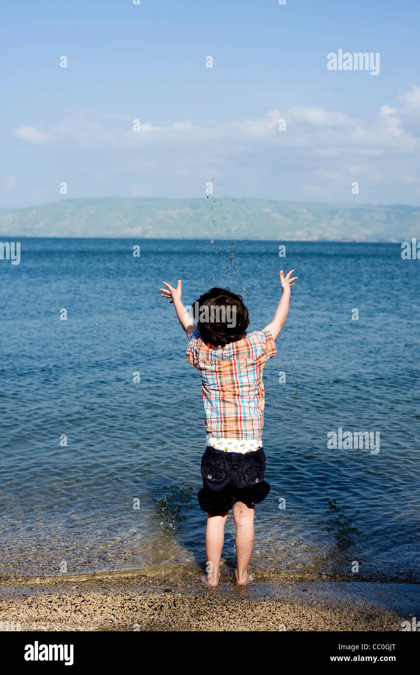 Boy throwing pebbles into the sea hi-res stock photography and images ...
