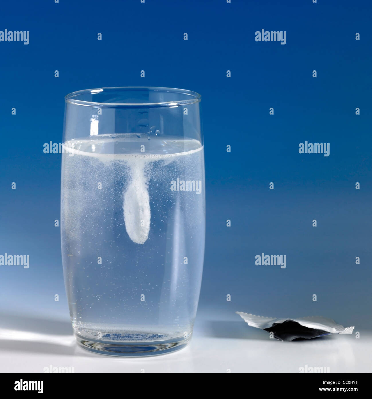 fizzy tablet while dissolving in a glass of water. Studio photography ...