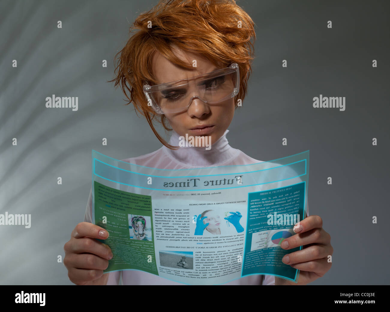 Beautiful woman reading newspaper from flexible hi-tech display ...