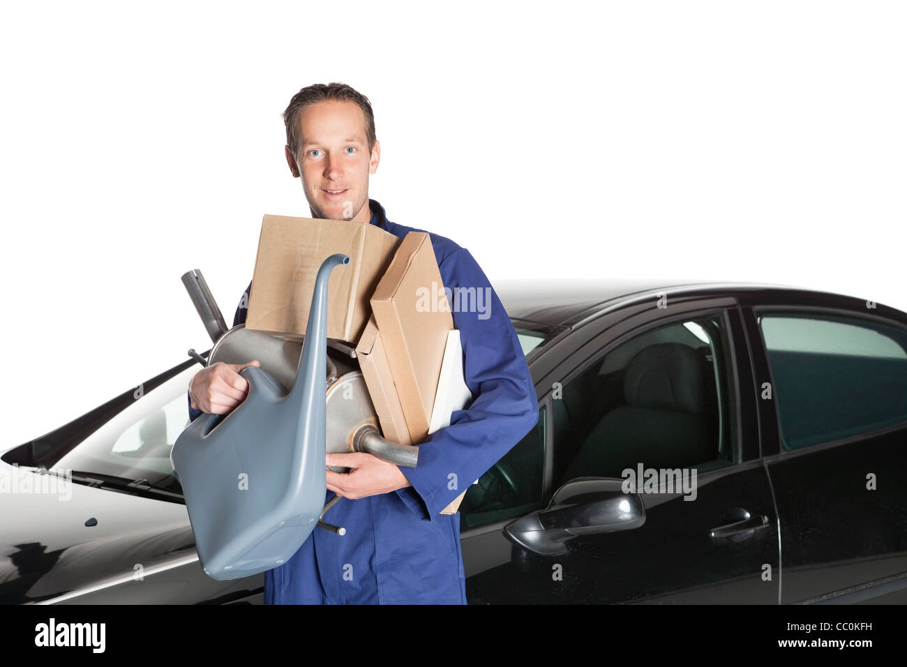 Portrait of confident worker with handful of mechanic stuff in front of ...