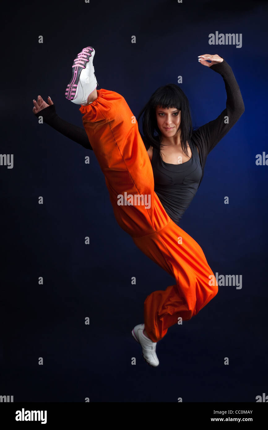Young woman jump front view with her leg up Stock Photo - Alamy