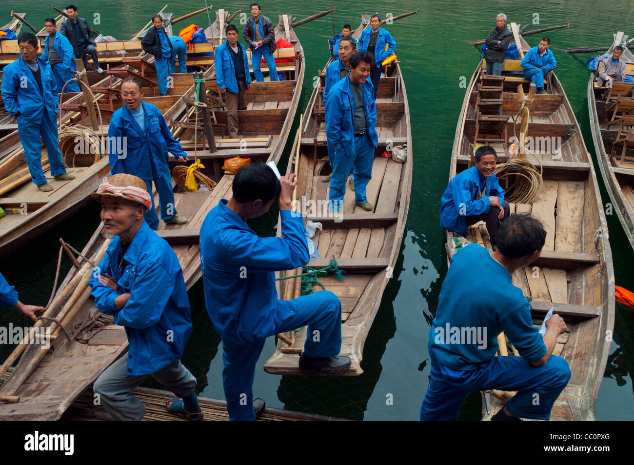 China, Yangtze River. Boatmen waiting for tourists to board traditional ...