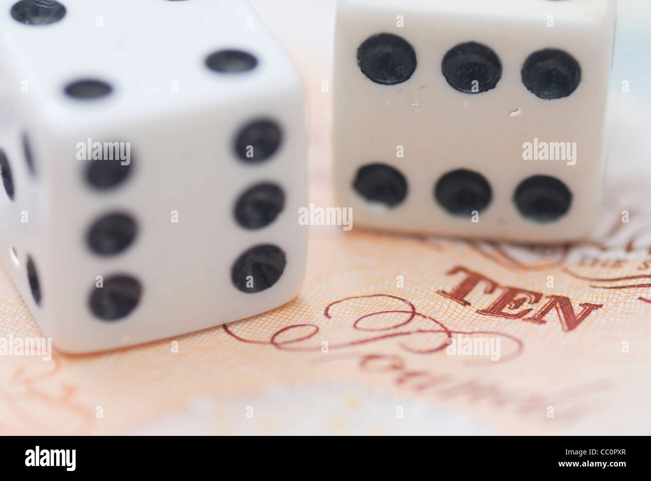 Two Dice on Bank Note, pound sterling Stock Photo - Alamy