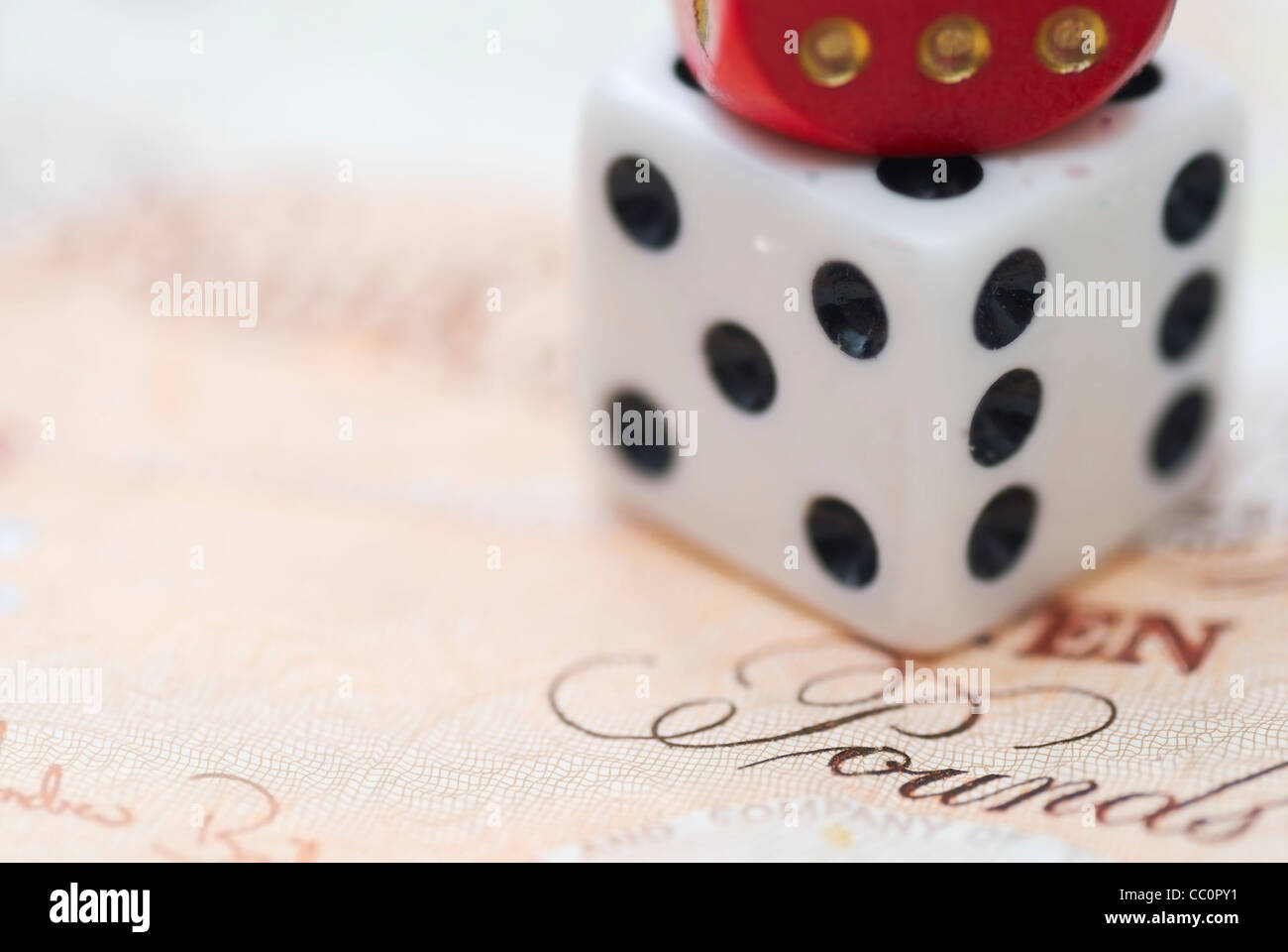 Two Dice on Bank Note, pound sterling Stock Photo - Alamy
