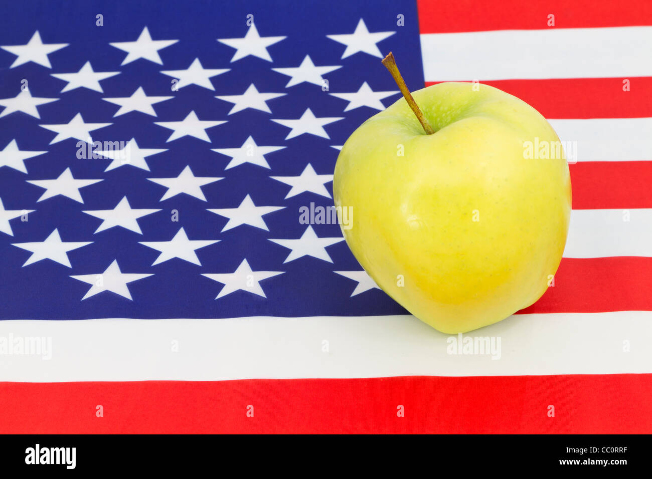 Golden apple, symbol of education, sits on American flag Stock Photo ...