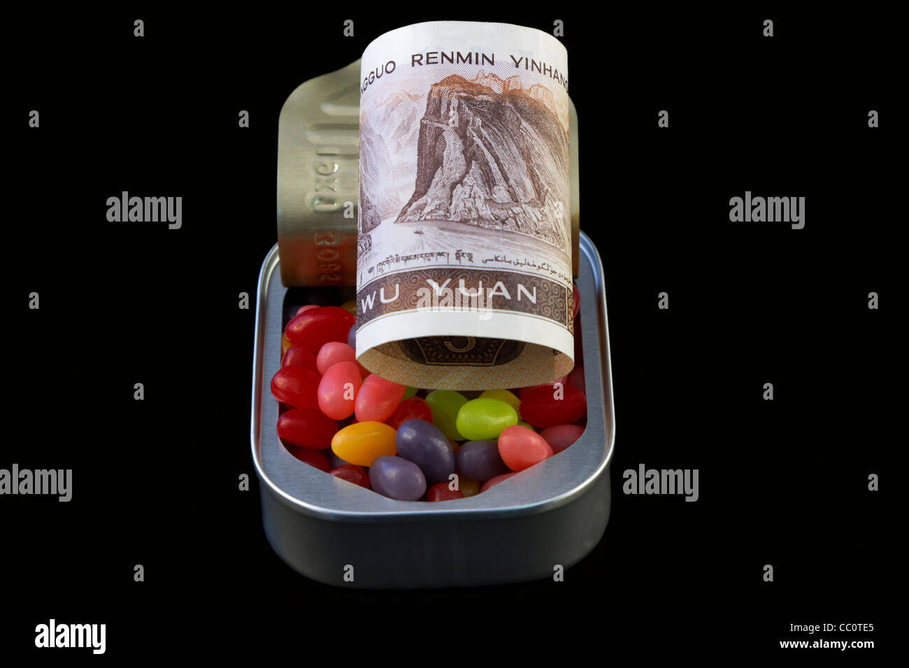 China's currency, yuan, showed in opened can filled with candy and ...