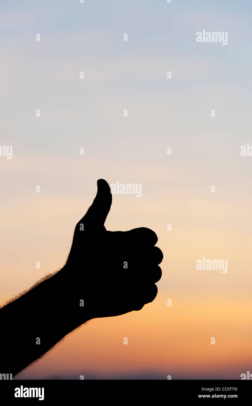 Thumbs up hand silhouette against sunrise sky Stock Photo - Alamy