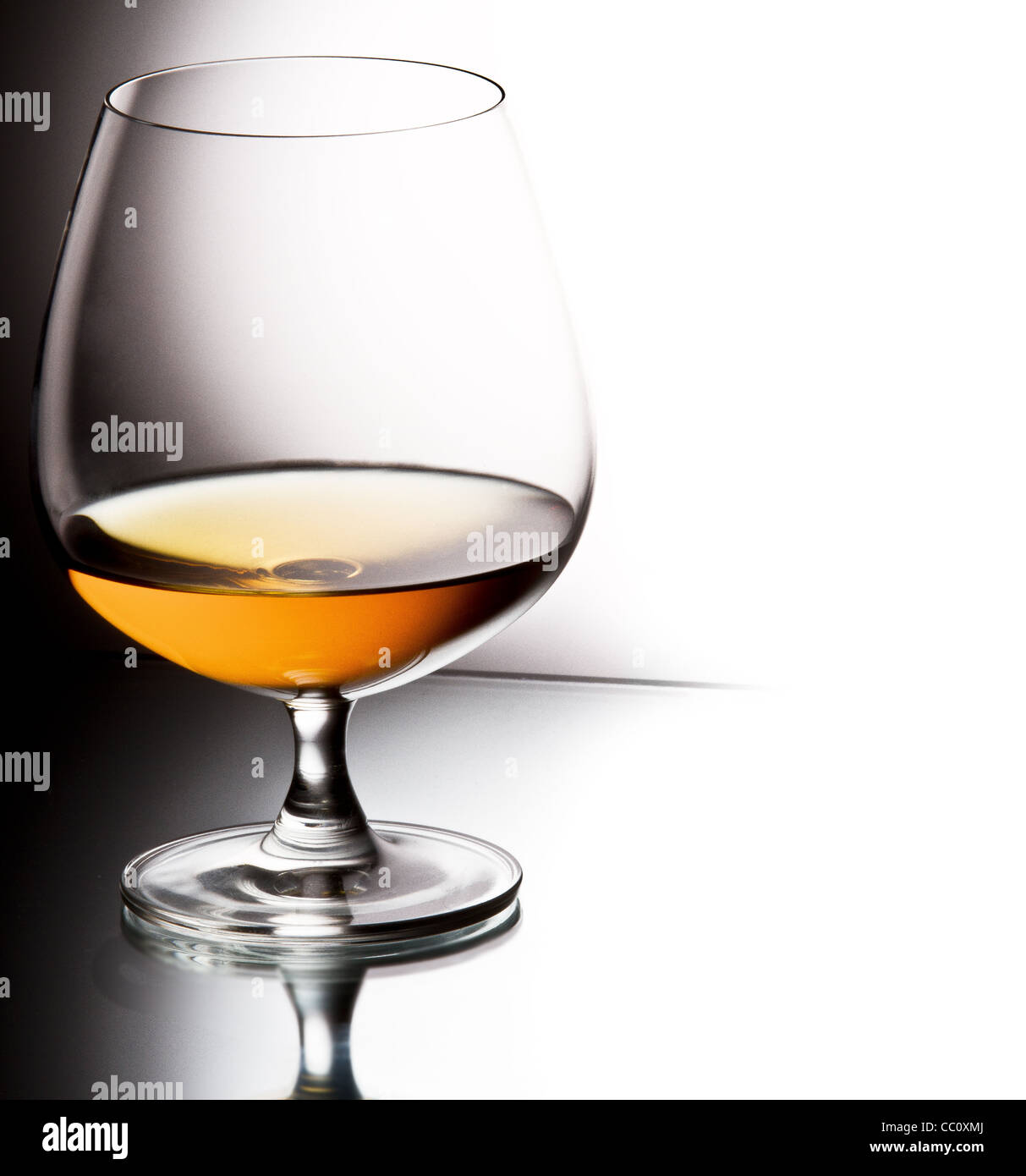 Glass of brandy over white background Stock Photo - Alamy