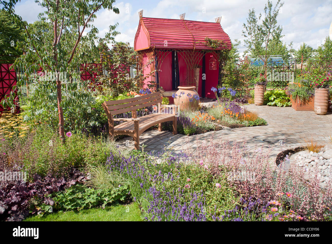 Red pavilion with paved patio and decorative sculpture Stock Photo - Alamy