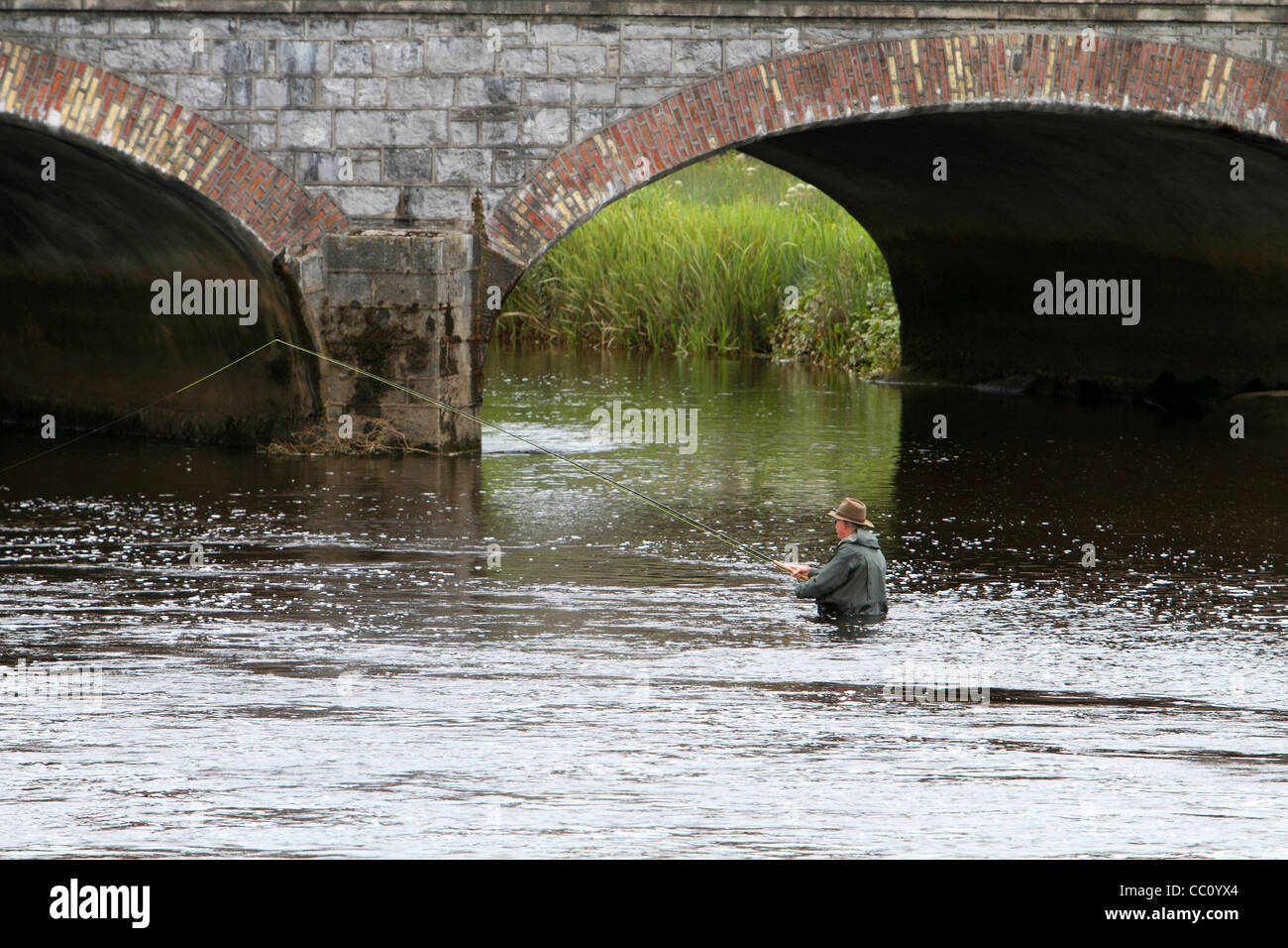 Man fly fishing besidev a bridge in the river Moy. Ballina. Co. Mayo ...