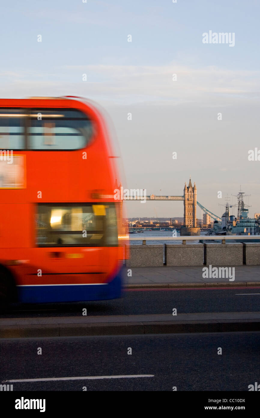 A red London bus traveling over London Bridge in the day time with ...