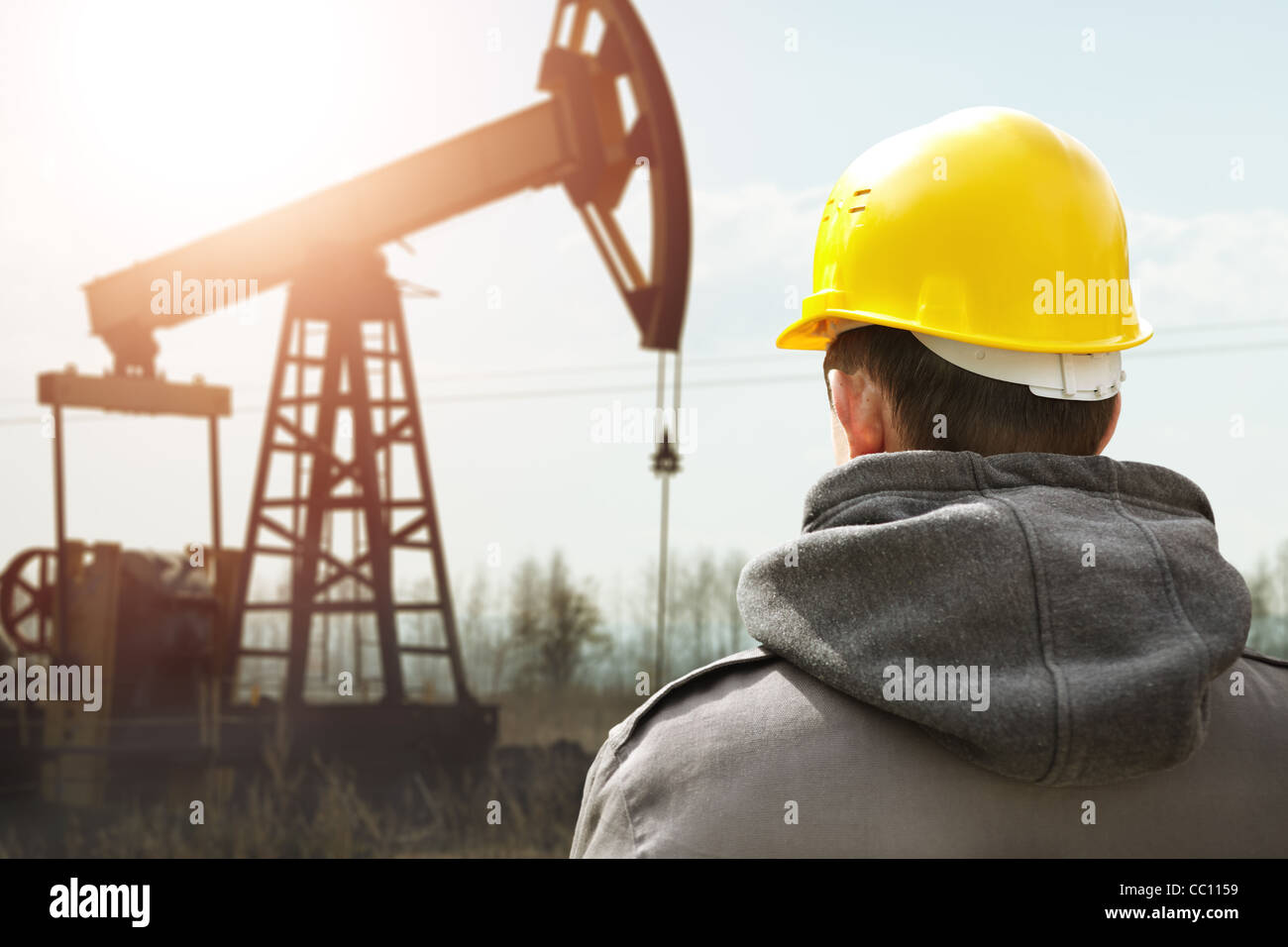 Oil worker in yellow helmet on of background the pump jack Stock Photo ...