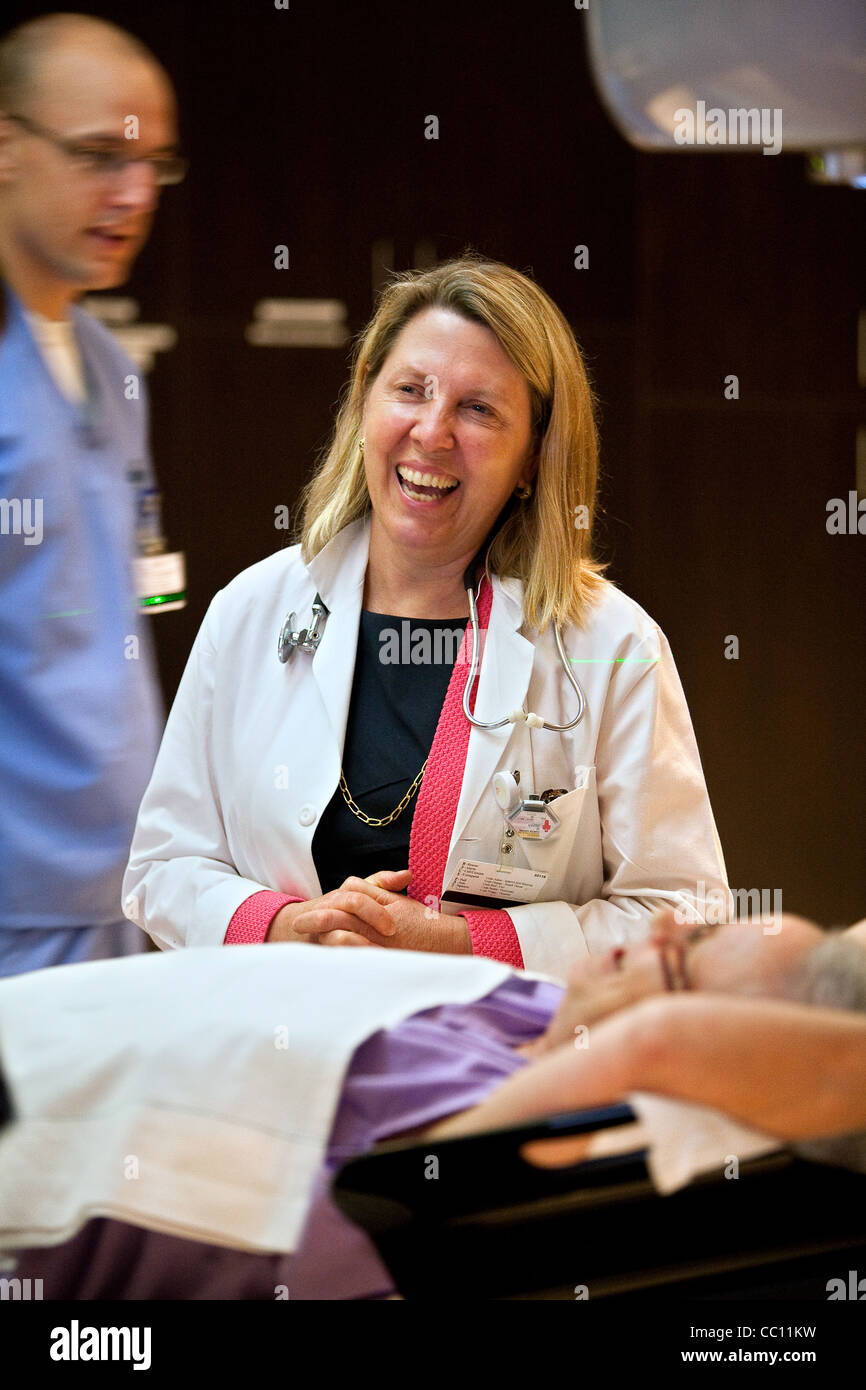 An oncologist doctor visits with a patient before a radiation treatment ...