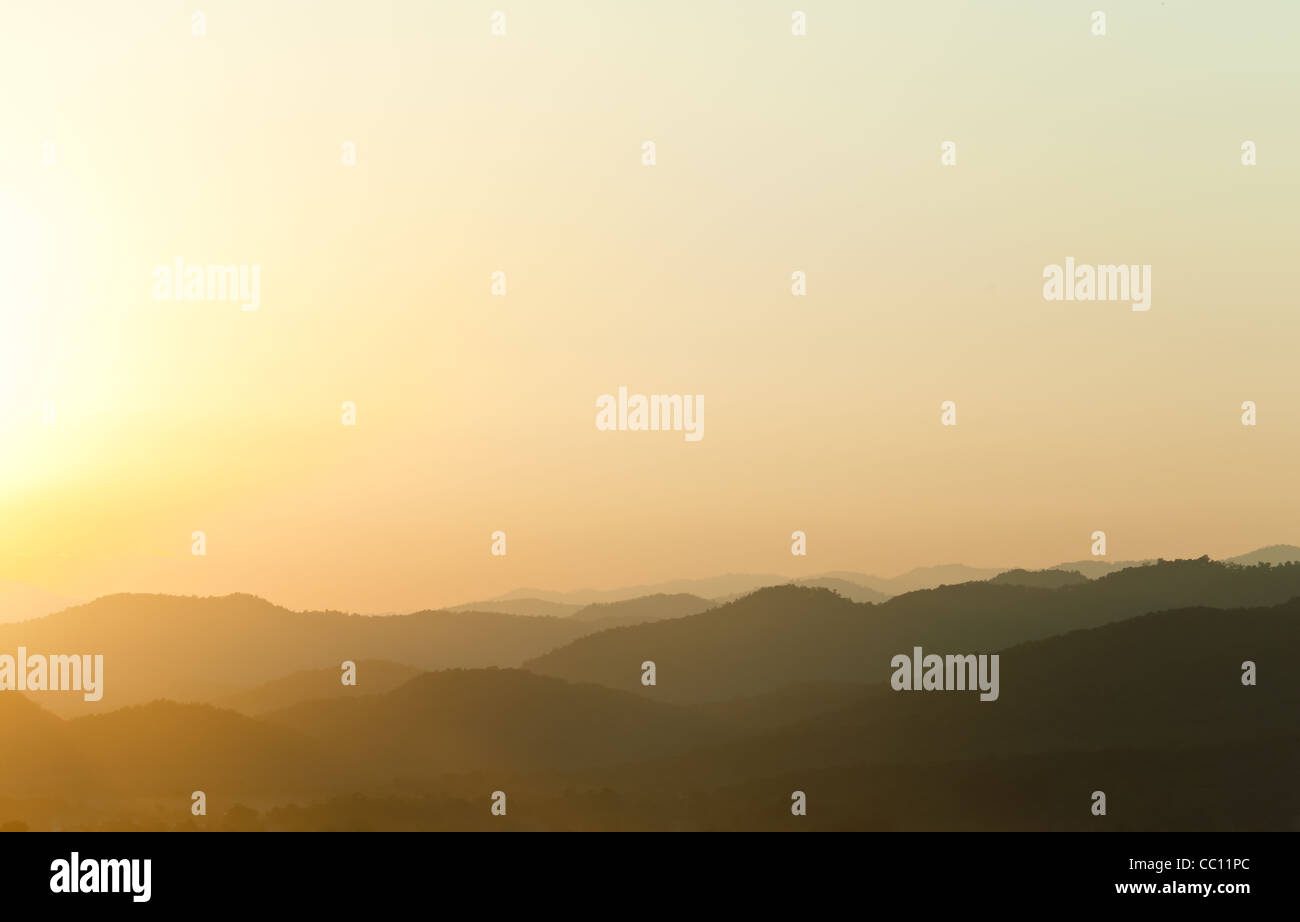 Sunset behind mountains with golden color Stock Photo - Alamy