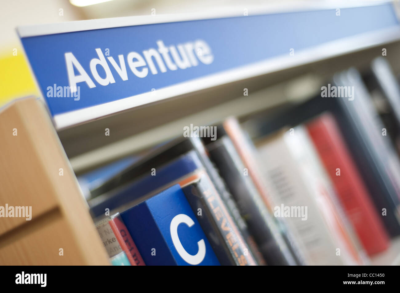 Adventure books on library shelves Stock Photo - Alamy